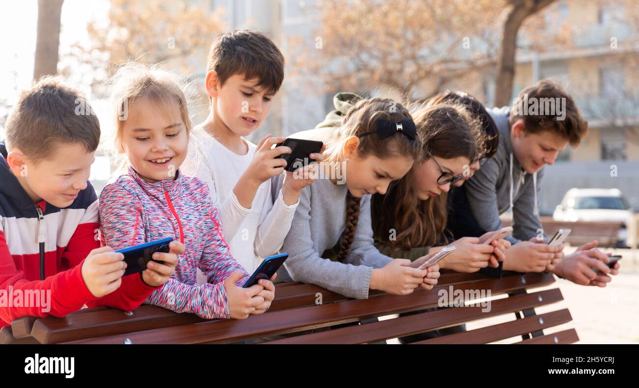 Children addicted in their phones outdoors Stock Photo - Alamy