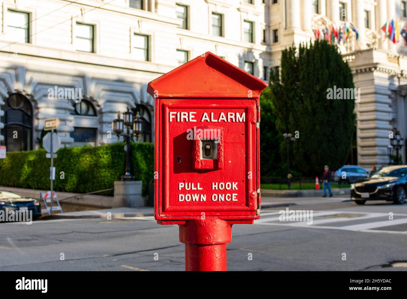Fire alarm red pull box on a city street. Blurred urban background ...