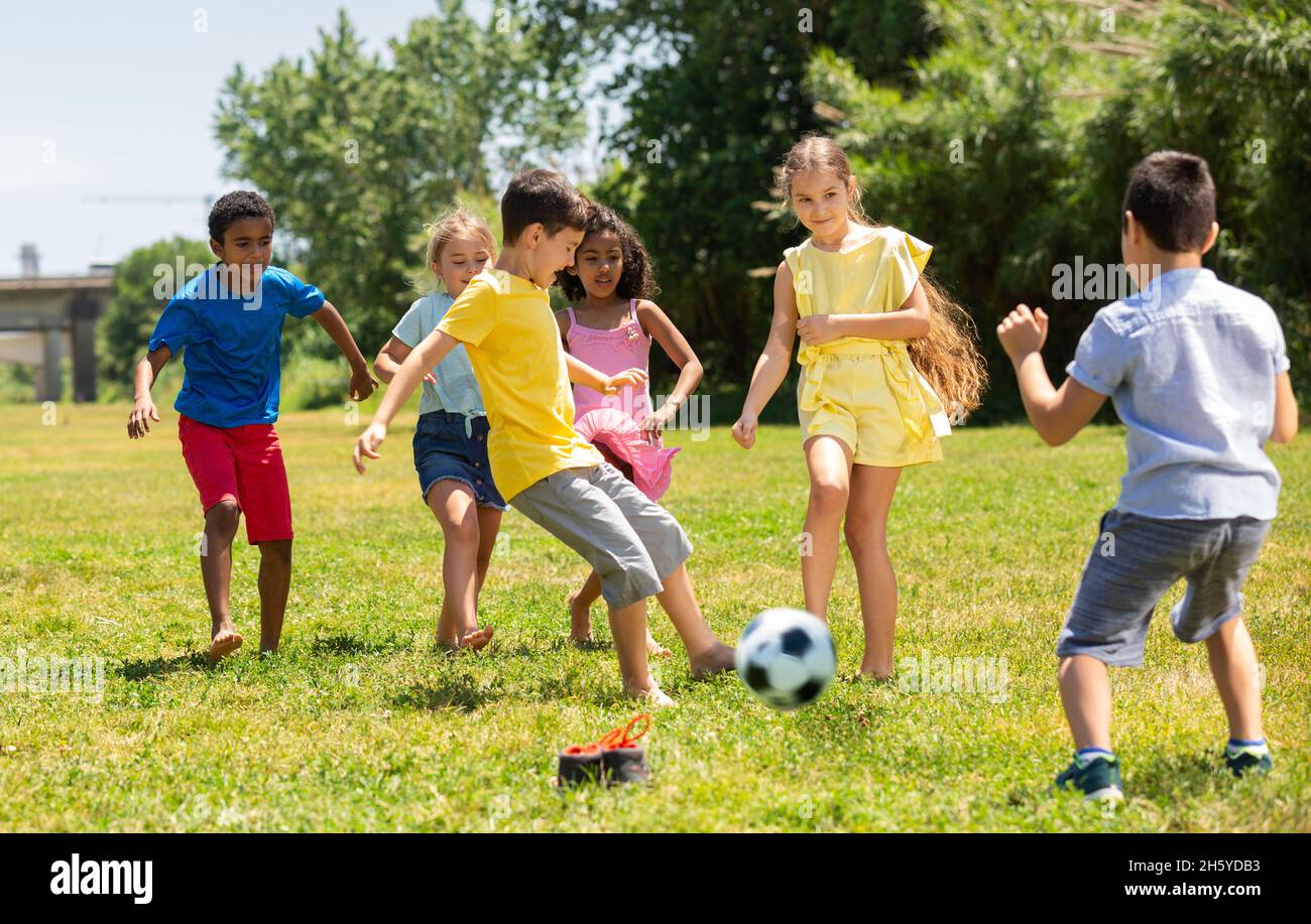 Group of happy schoolchildren playing football together Stock Photo - Alamy