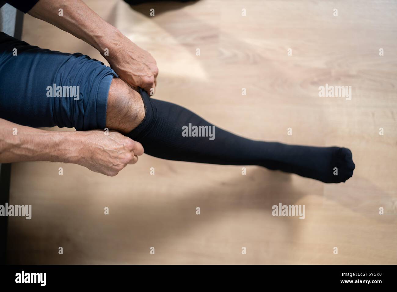 Man Putting On Medical Compression Stockings On Legs Stock Photo - Alamy