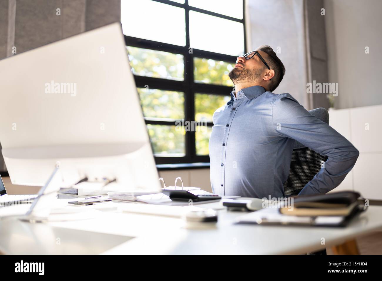 Back Pain Bad Posture Man Sitting In Office Stock Photo - Alamy
