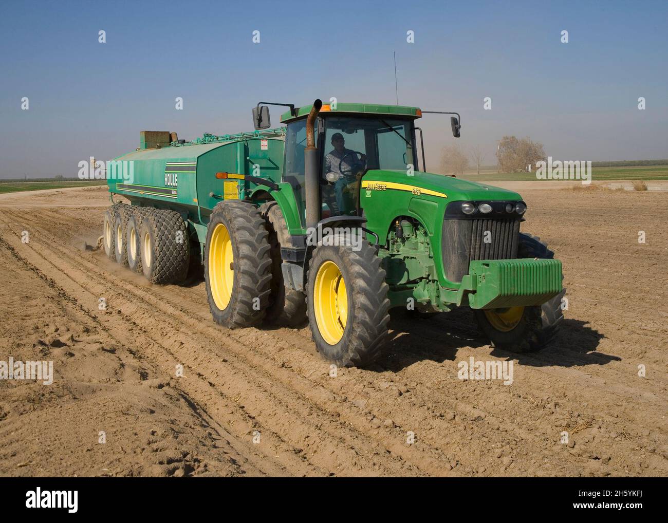 A farmer in his John Deere tractor in a dirt field ca. 2011 or earlier ...