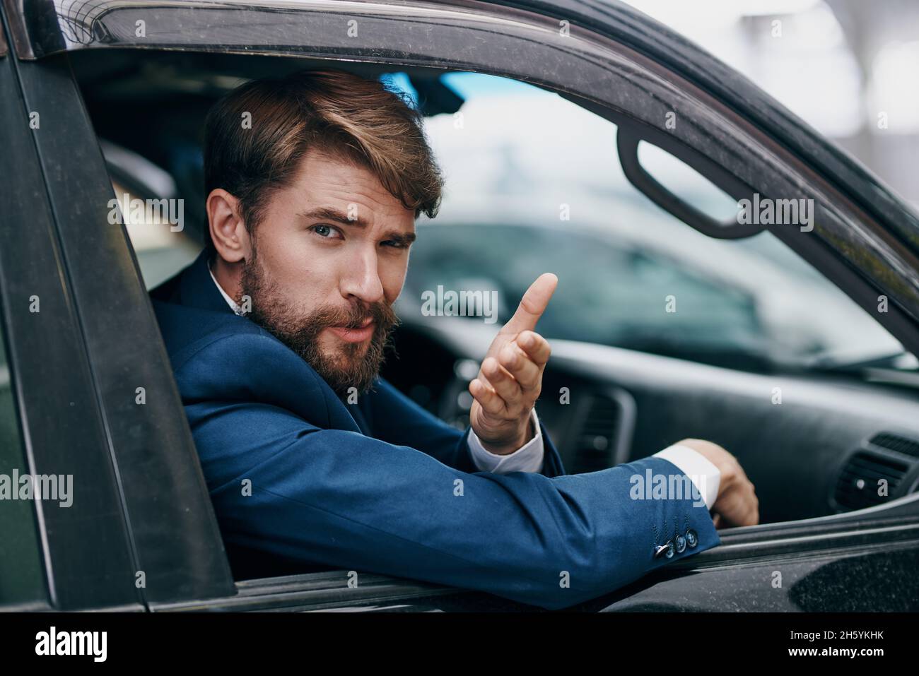 a man in a suit peeking out of a car window trip transportation Stock ...