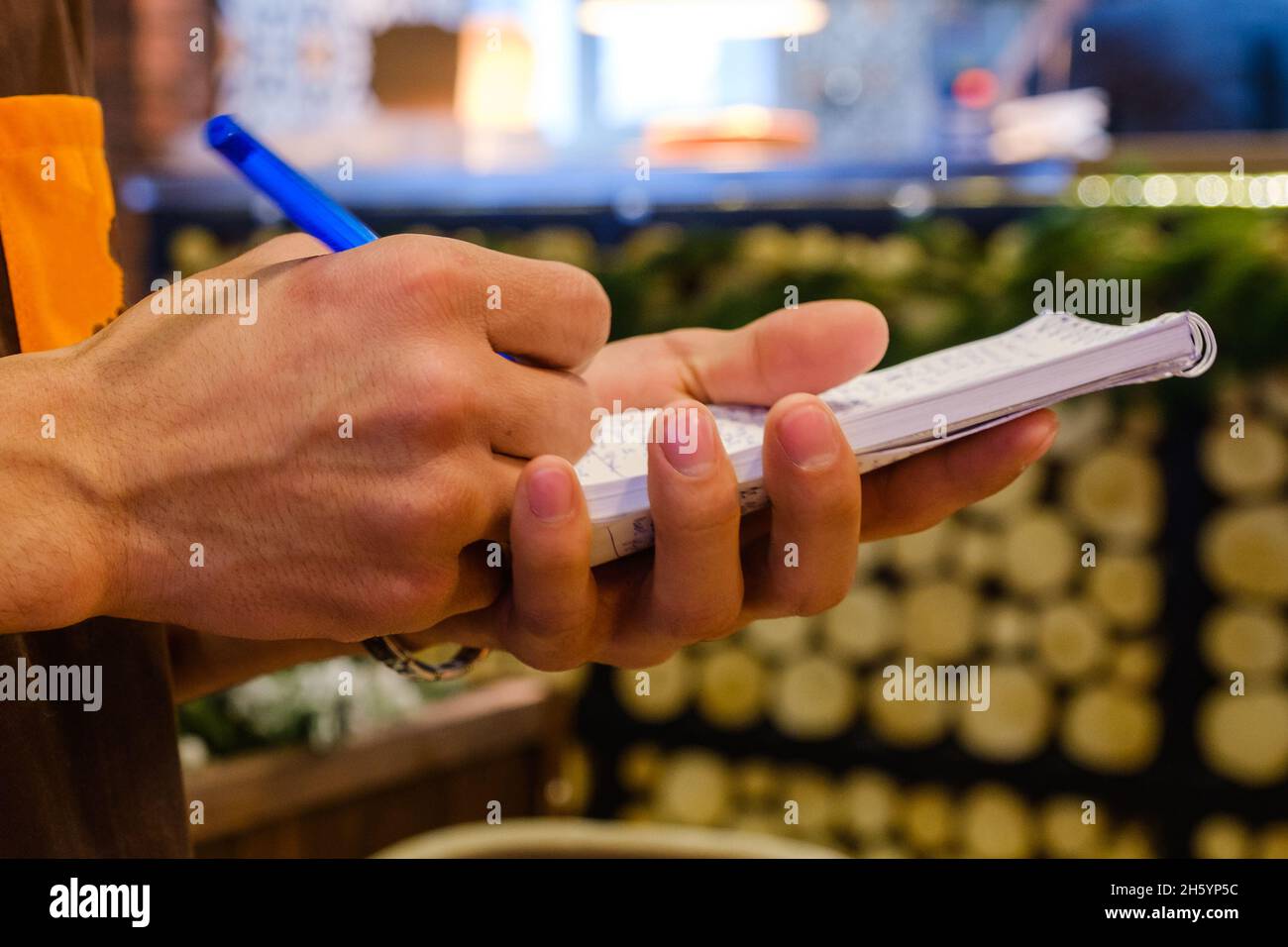 Hands of the waiter accepting the order Stock Photo - Alamy
