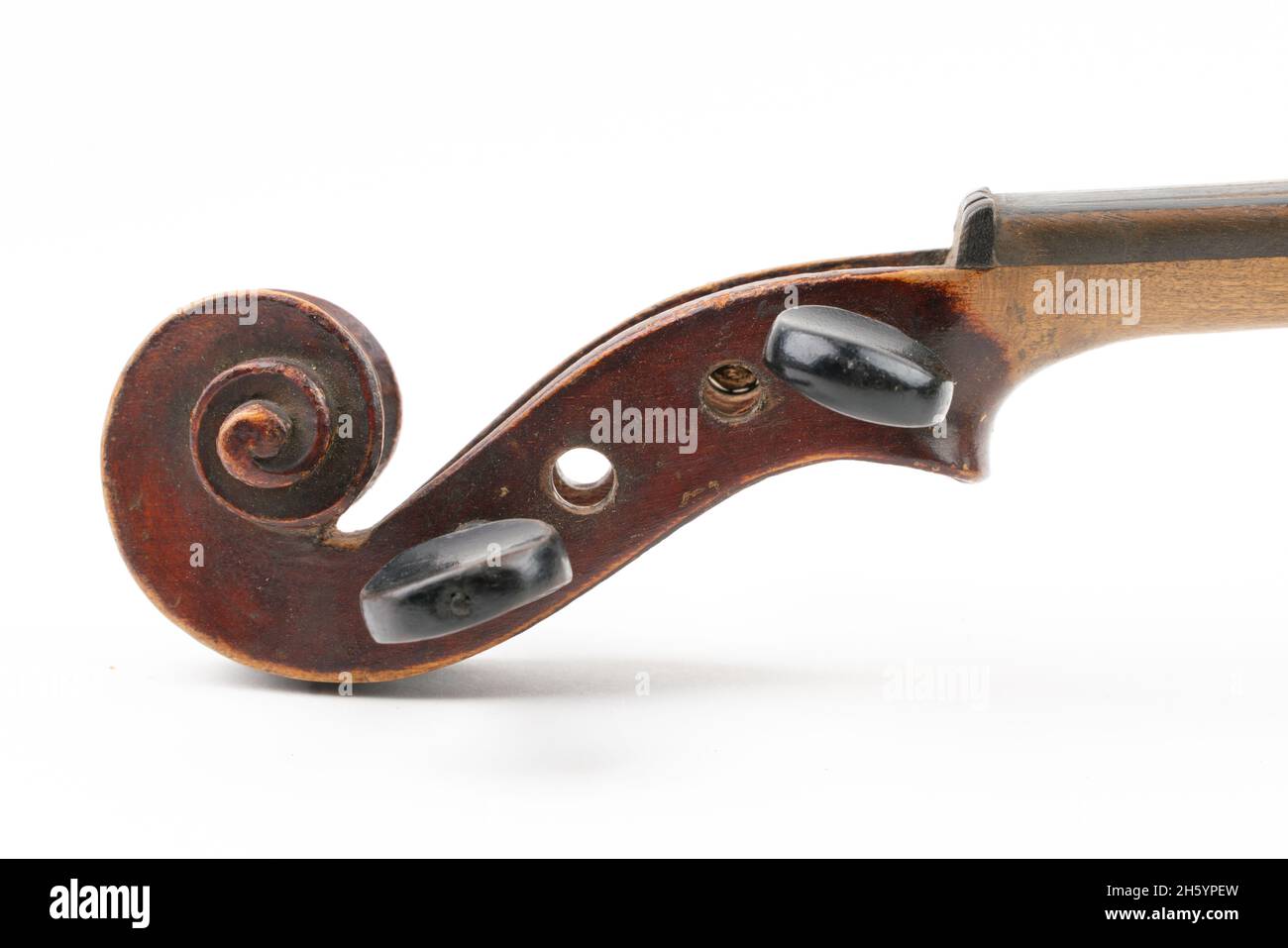 Detail studio shot of a head of old, broken violin with missing tuning ...