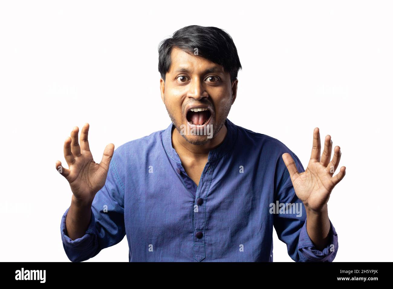 A young Indian male in blue dress with surprised shocked look and mouth ...