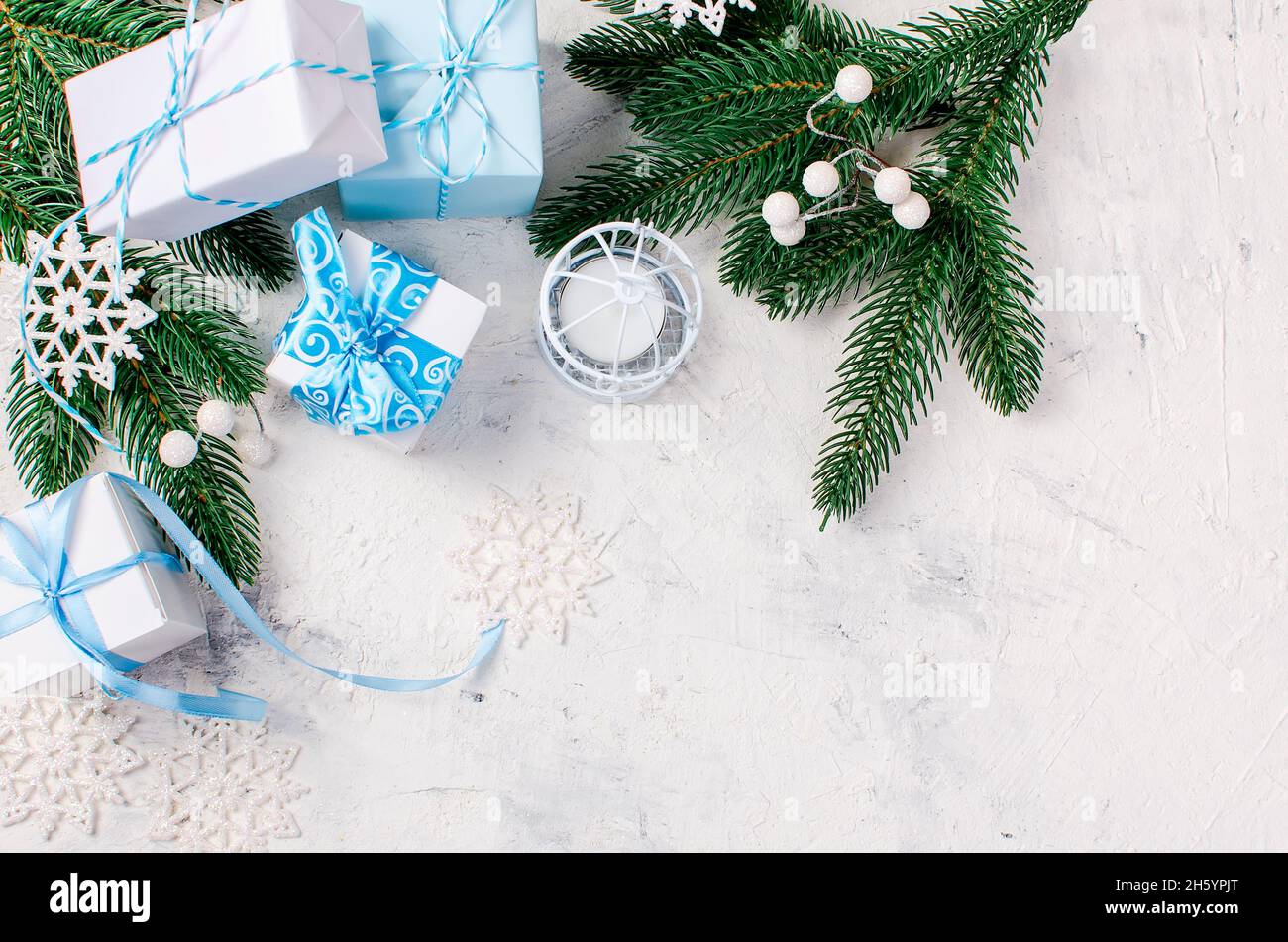 Christmas fir branches, blue and white gifts boxes with blue ribbon on ...