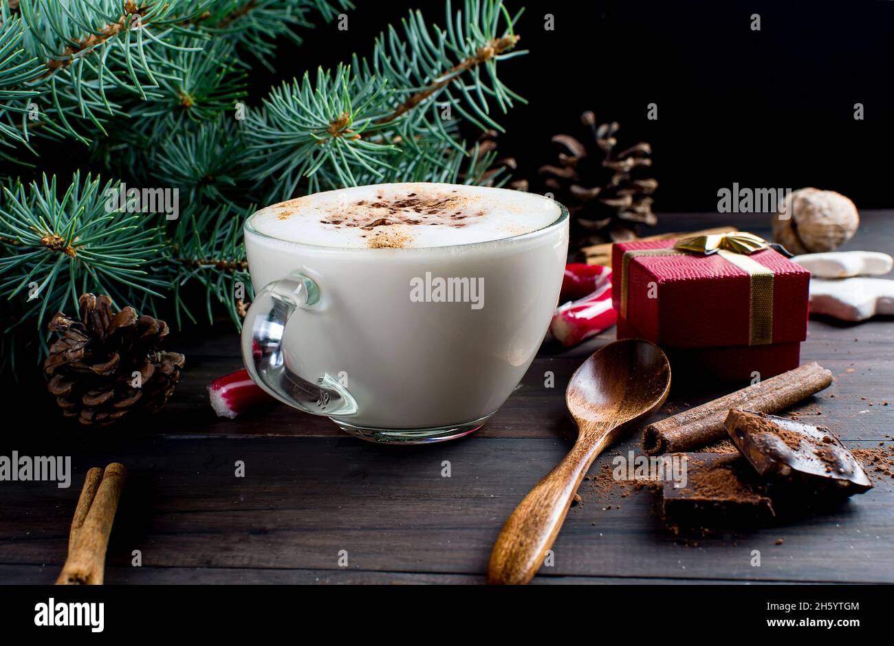 cup of hot cocoa or hot coffee latte with cinnamon, fir tree and ...