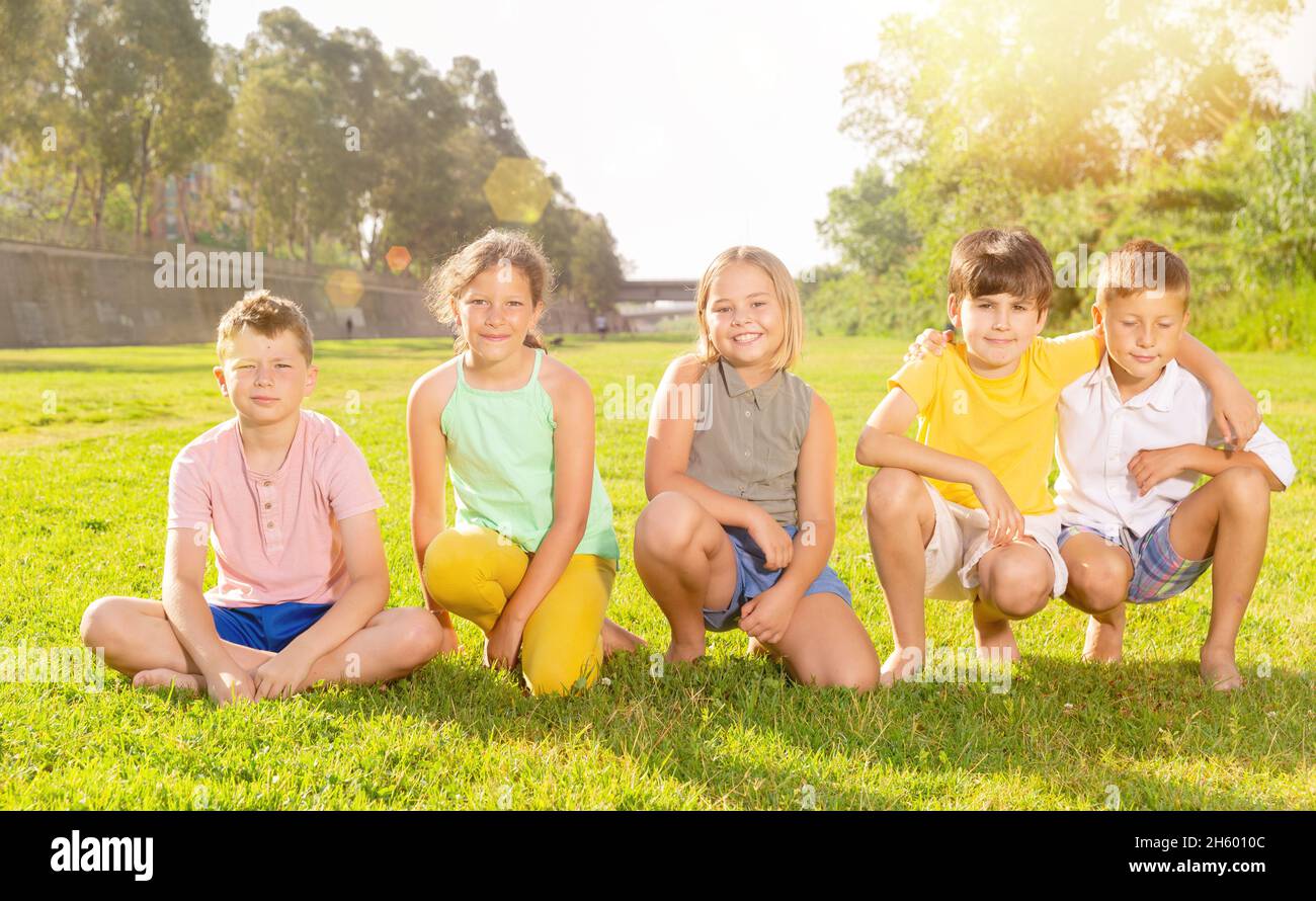Five kids sitting on grass Stock Photo - Alamy