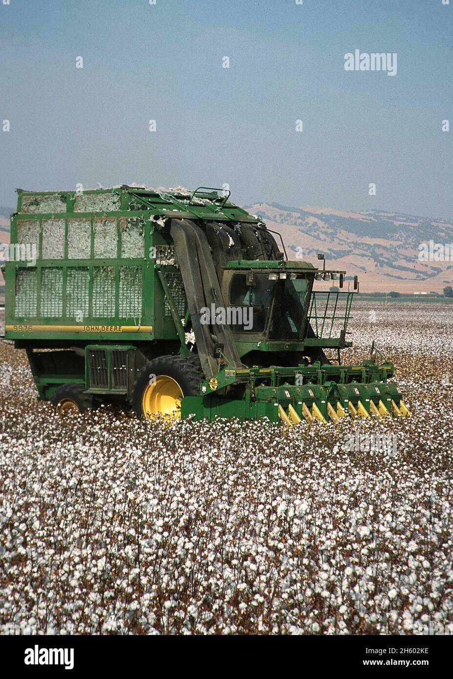 Farmer harvesting cotton in a John Deere cotton harvester ca. 2011 or ...