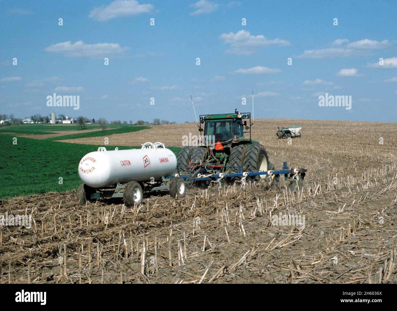 Tractor driving in a field in his John Deere tractor ca. 2011 or ...