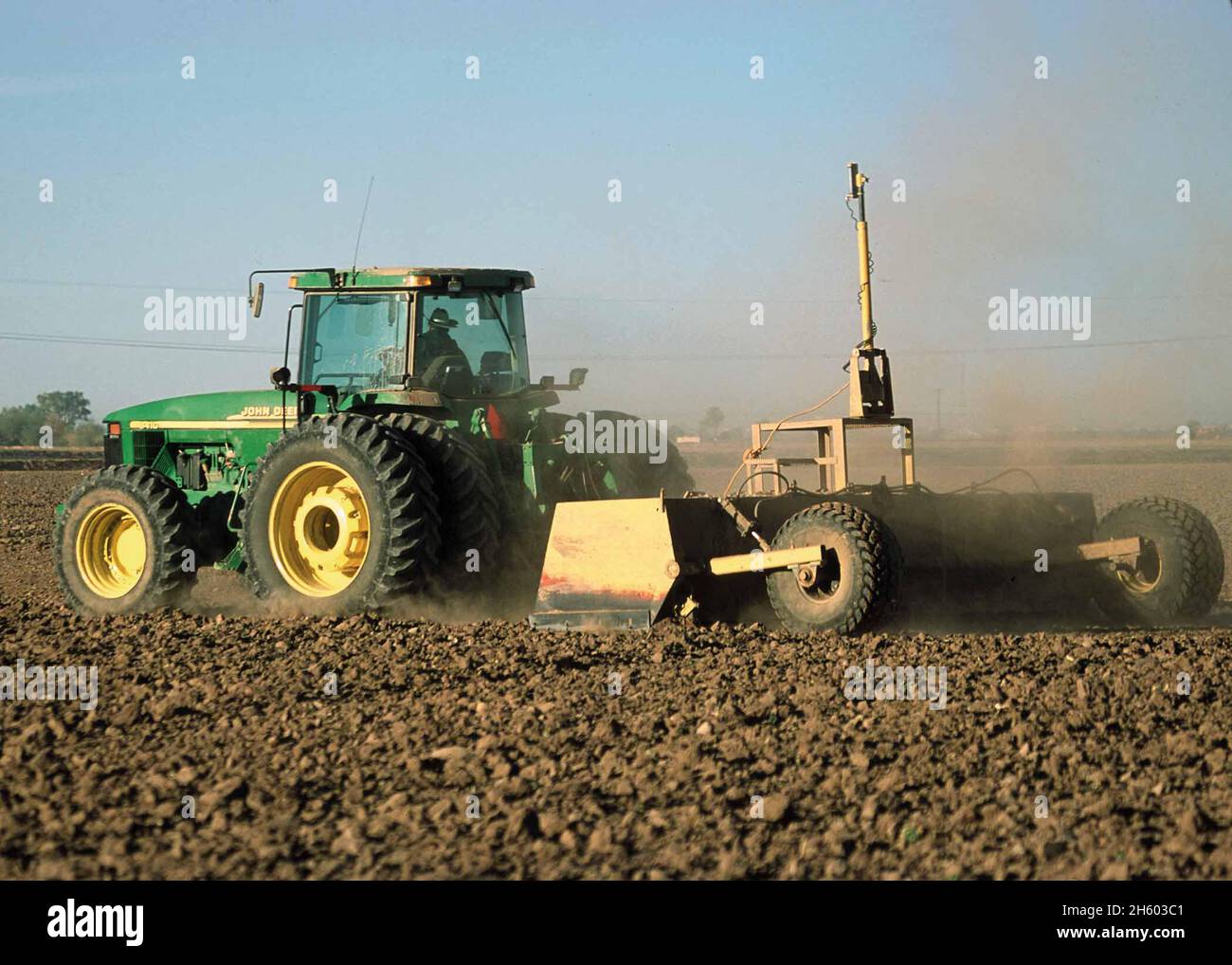 Farmer on his John Deere tractor in a field, tractor facing left ca ...