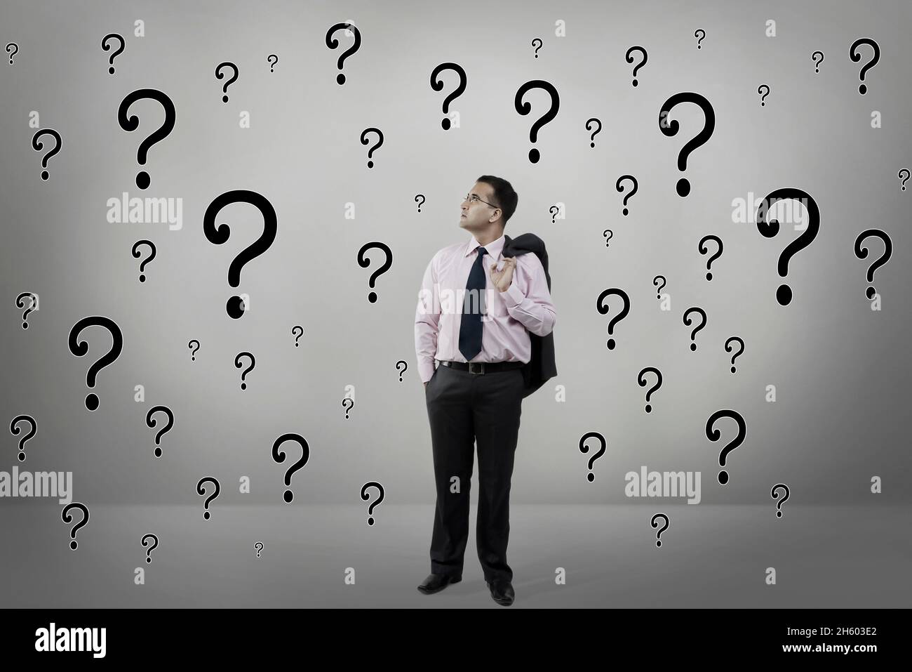 A corporate employee in formal business suit standing confused amidst ...