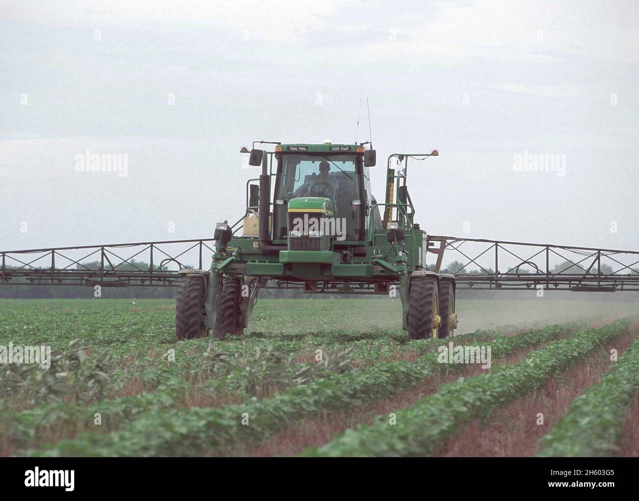 A farmer in his John Deere tractor fertilizing his crops ca. 2011 or ...