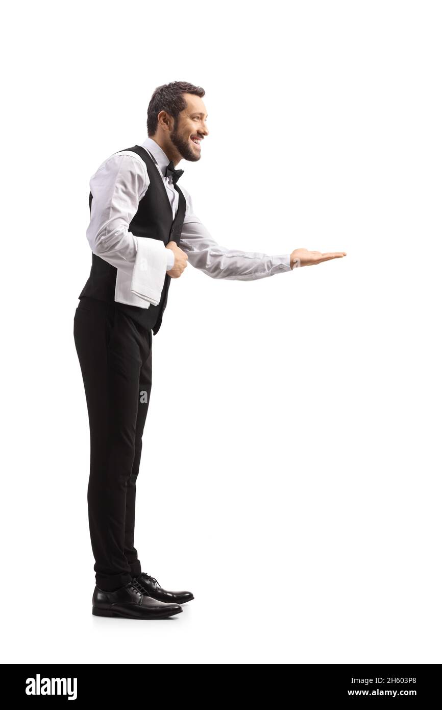 Full length profile shot of a polite elegant waiter gesturing with hand ...
