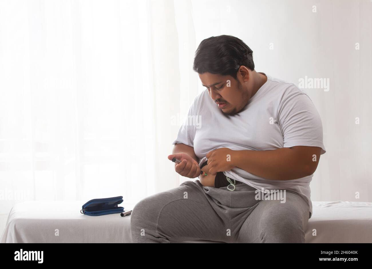 A fat fan trying to treat obesity with syringe by applying insulin ...