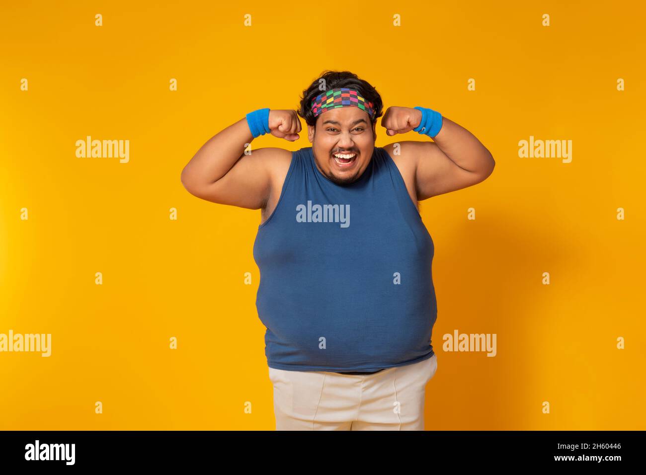 Portrait of a fat man smiling and showing his muscles by clenching ...