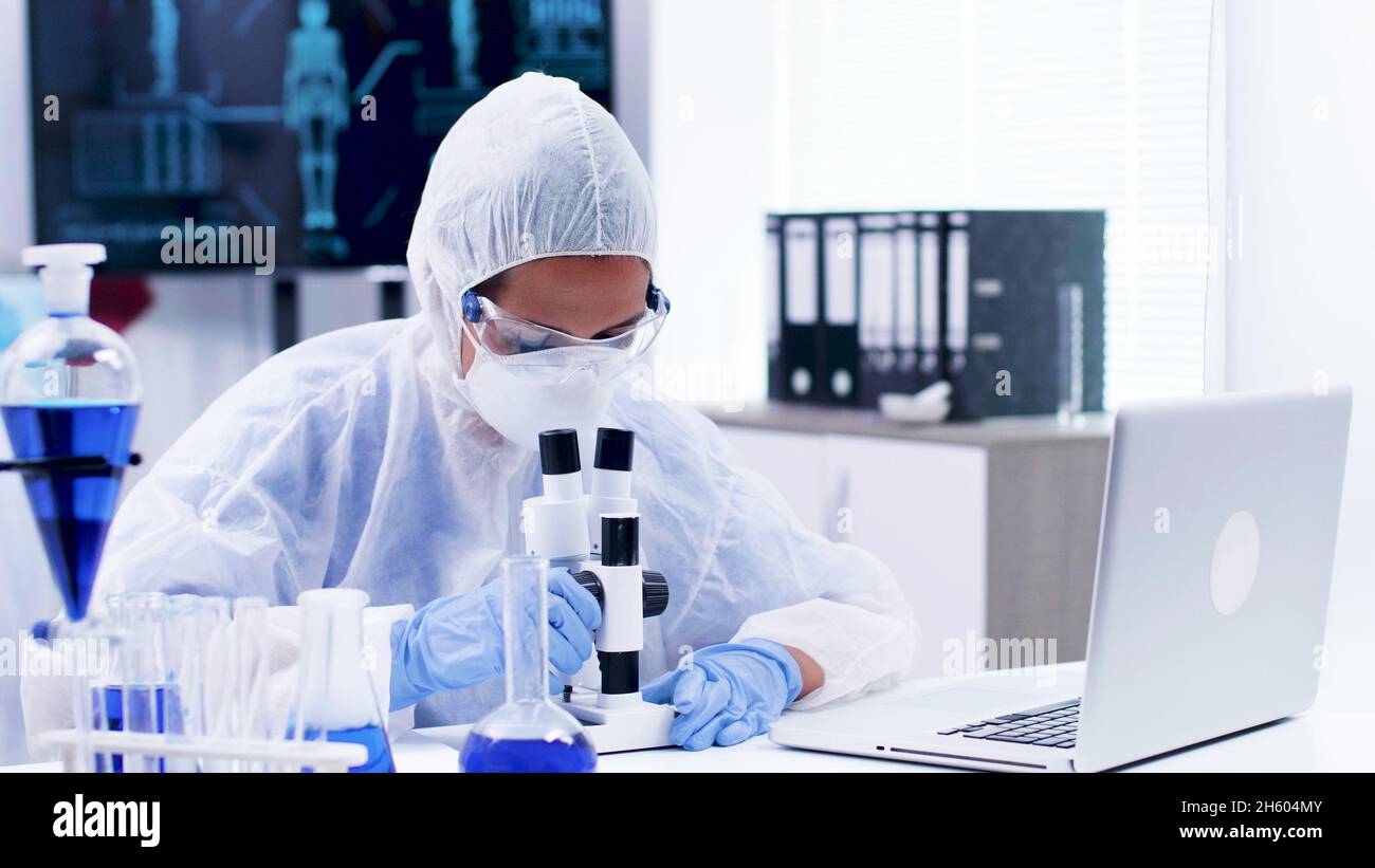 Specialist researcher doctor wearing ppe equipment looking into ...
