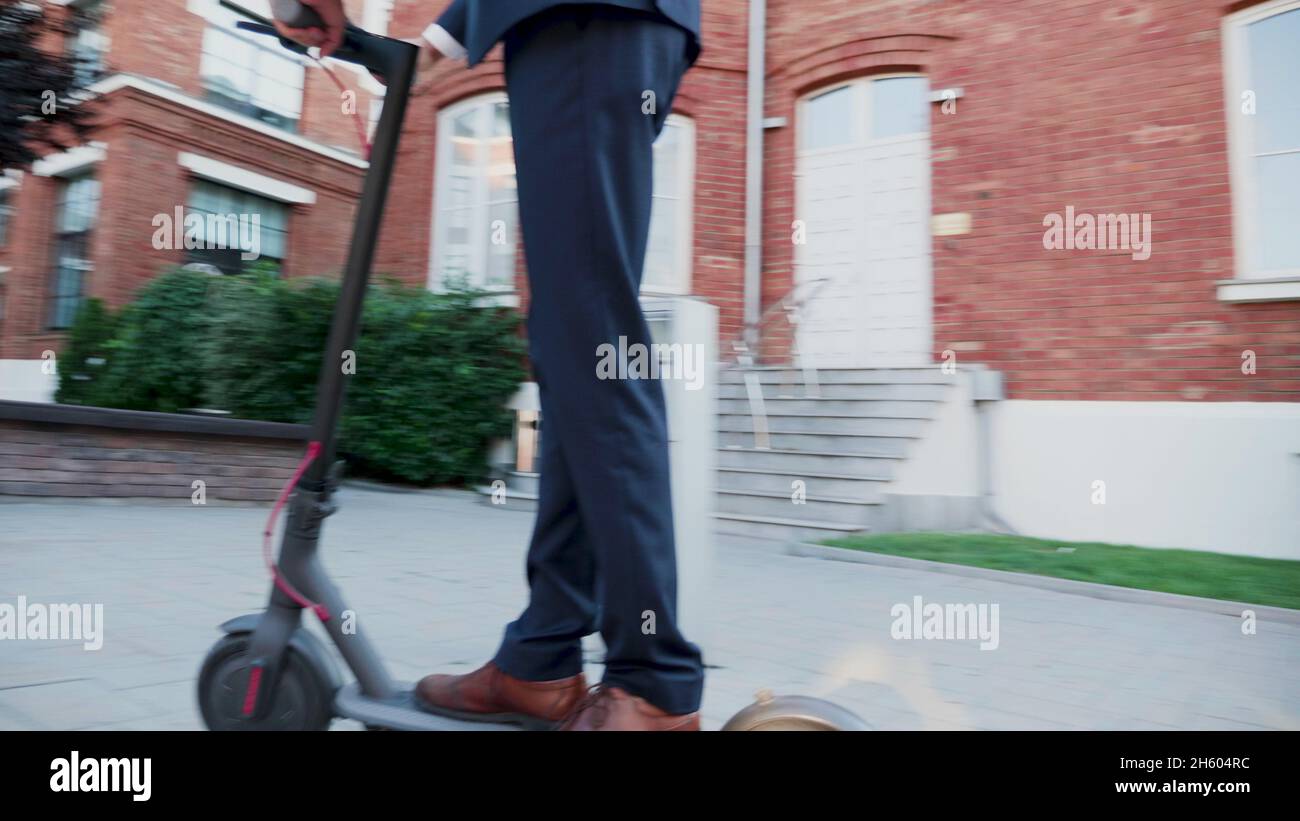 Diplomatic man in business suit riding on electric scooter to company ...