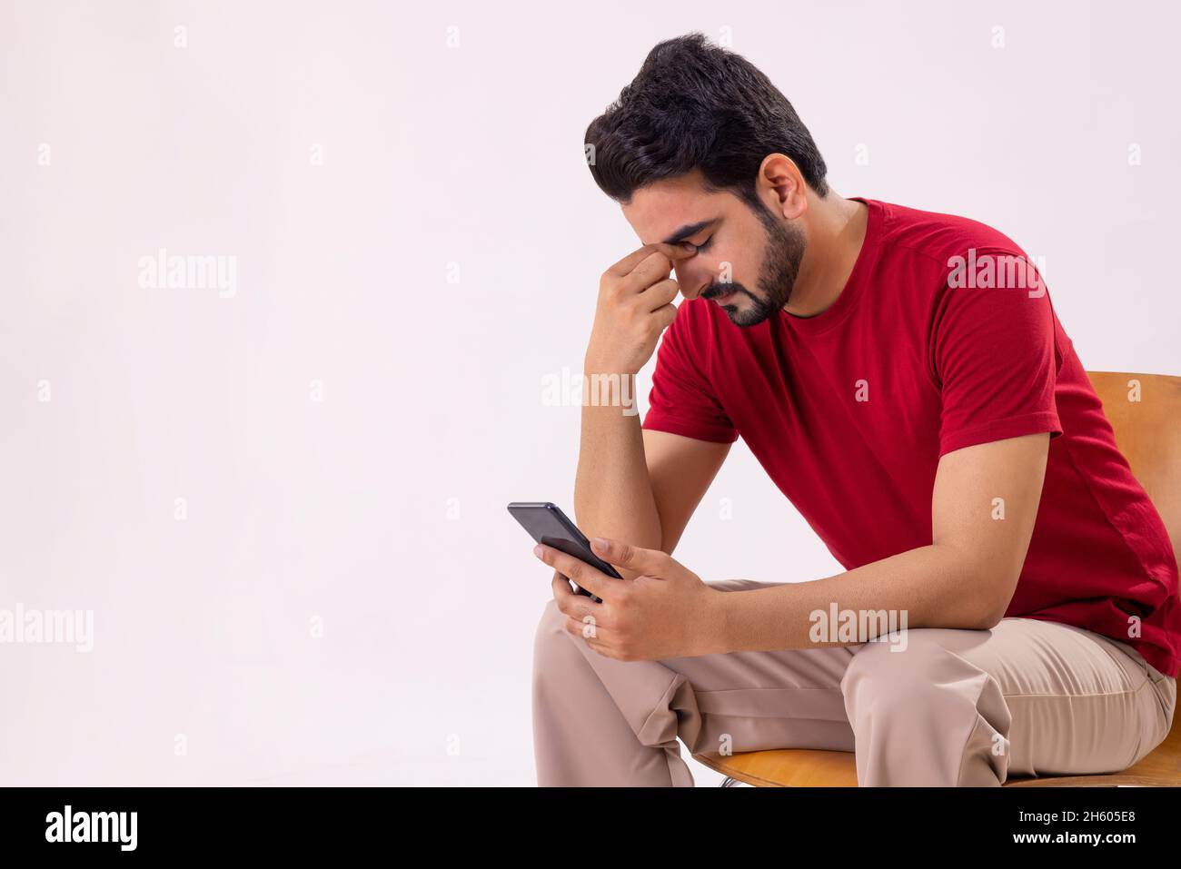 A TENSED MAN SITTING ALONE WHILE HOLDING MOBILE PHONE Stock Photo - Alamy