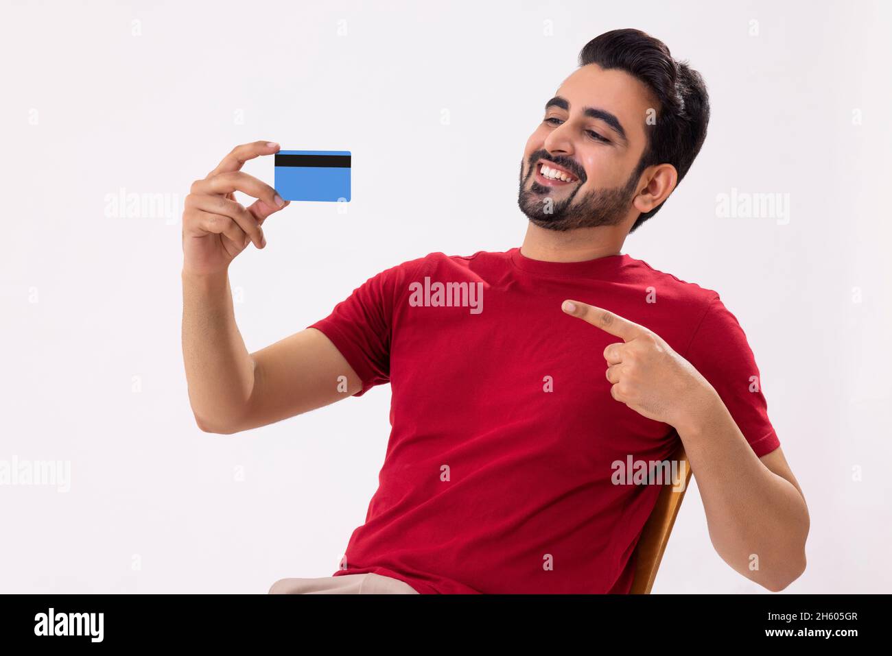 A HAPPY MAN POINTING TOWARDS DEBIT CARD IN HAND Stock Photo - Alamy