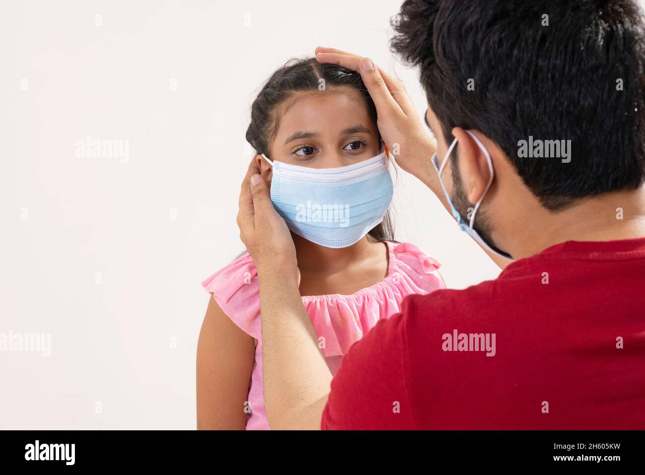 A FATHER CAREFULLY CHECKING FACE MASK OF DAUGHTER TO PROTECT FROM ...
