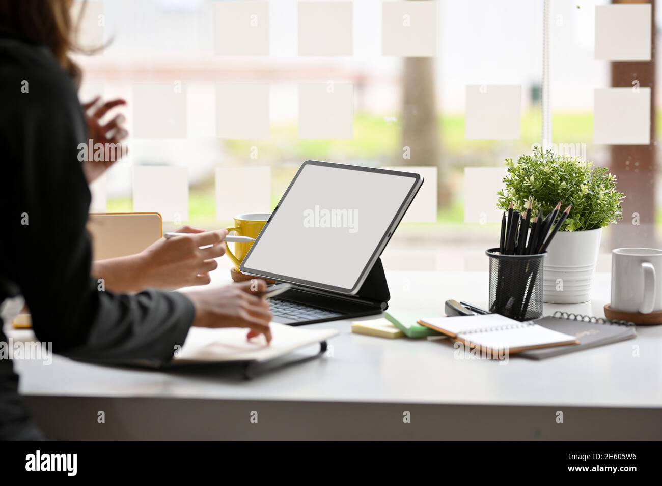 Female employee using digital tablet computer with her coworker in ...