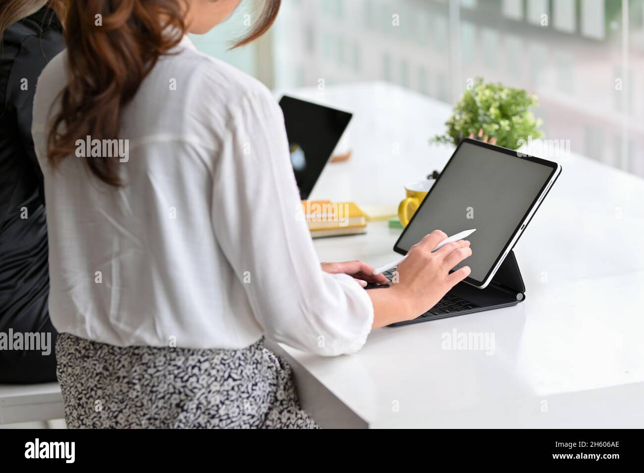 Female secretary using wireless tablet computer, working on touchpad ...