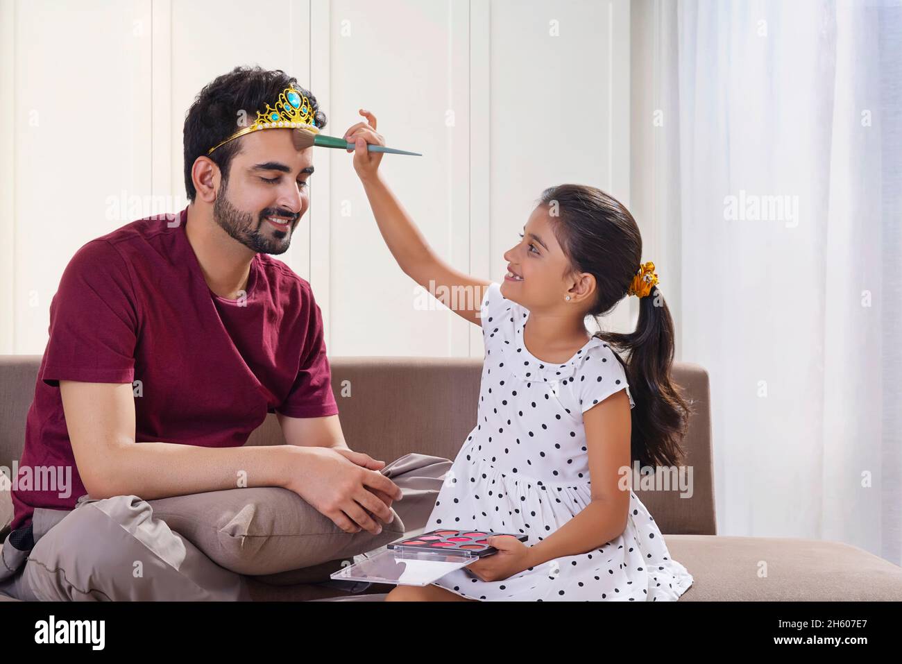 A HAPPY DAUGHTER PUTTING MAKEUP ON FATHER WHILE PLAYING AT HOME Stock ...
