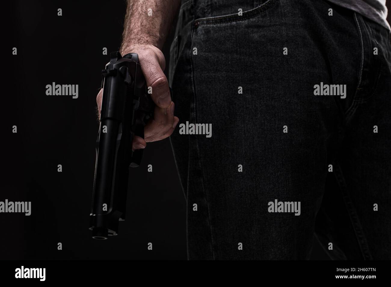 Killer with gun on black background at the studio Stock Photo - Alamy