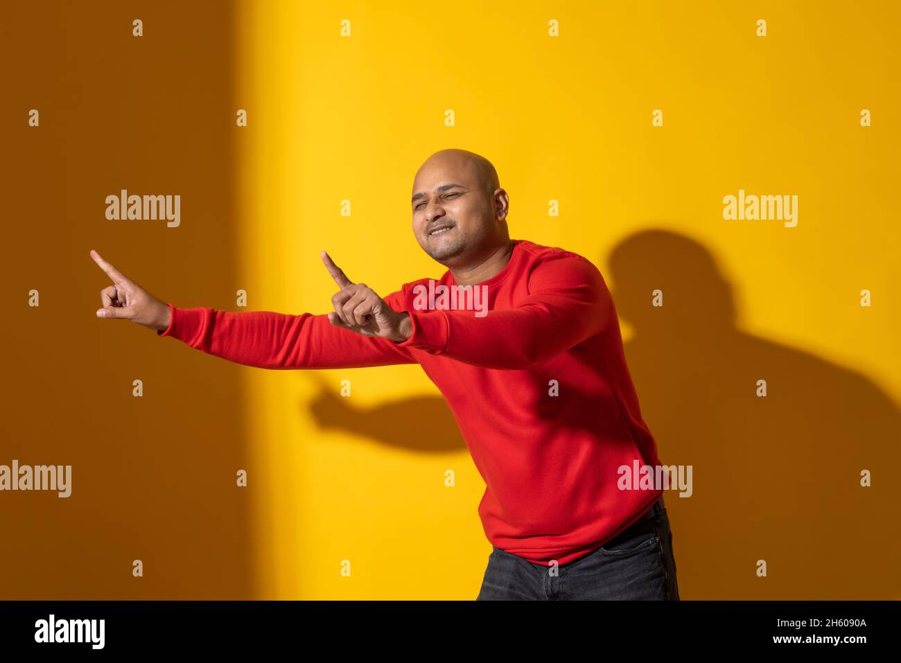 Portrait of a bald man dancing against plain background Stock Photo - Alamy