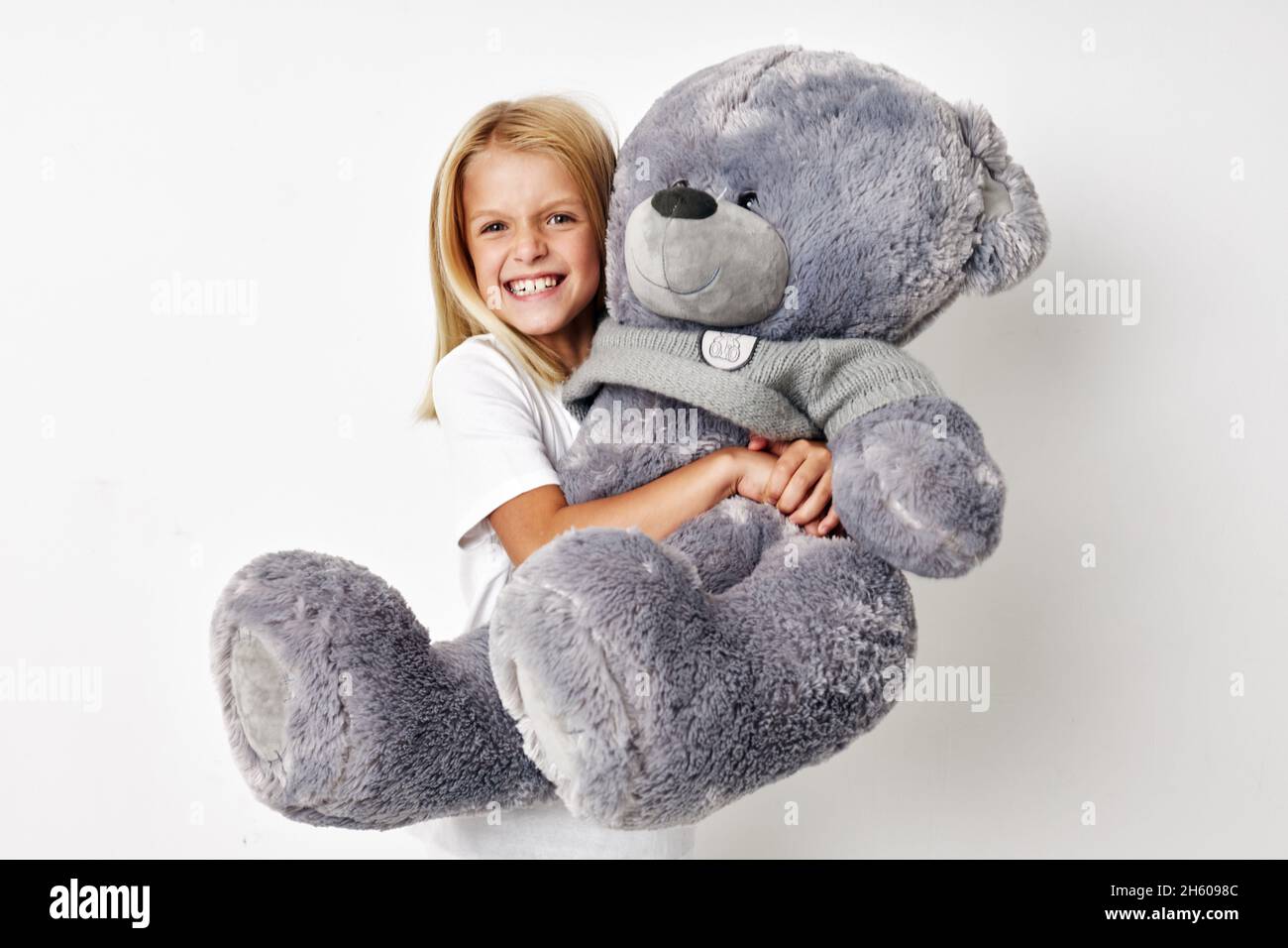 Positive little girl fun teddy bear joy on a light background Stock ...