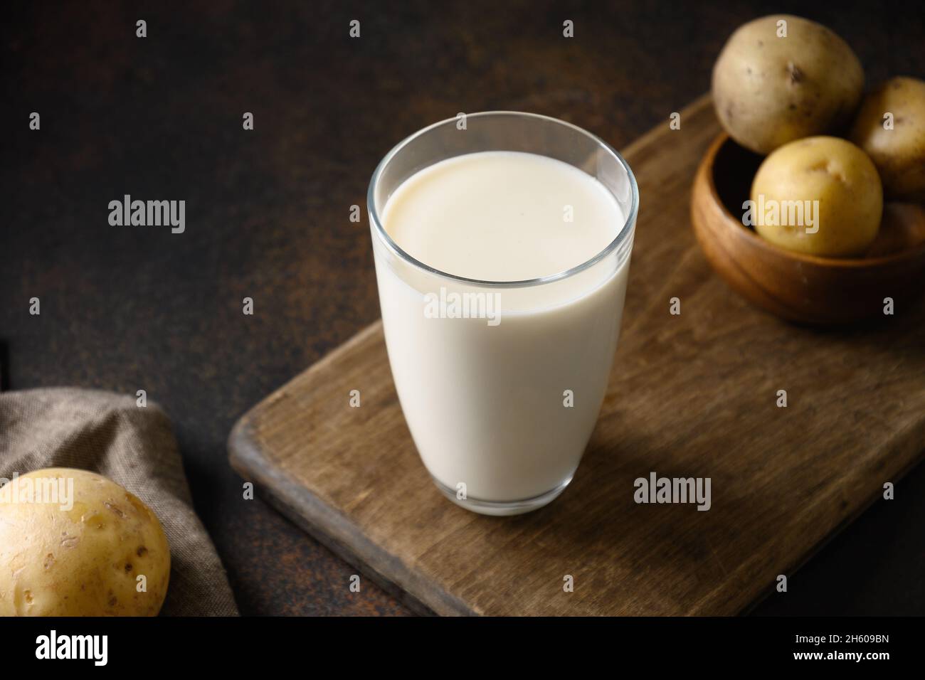 Vegan potato milk and potato on brown background. Close up. Plant based ...