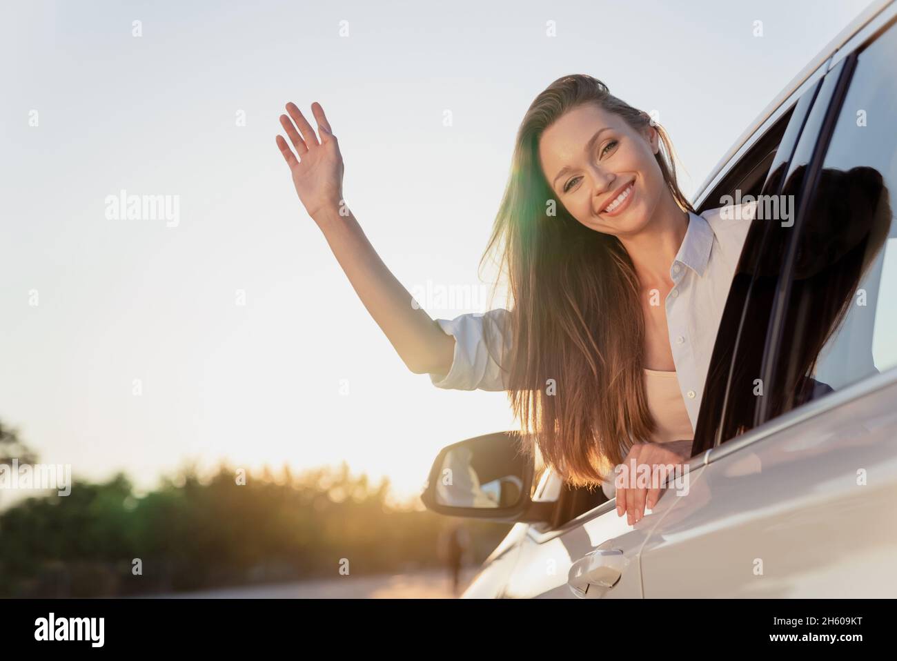 Photo portrait smiling woman riding in car looking in window in shirt ...