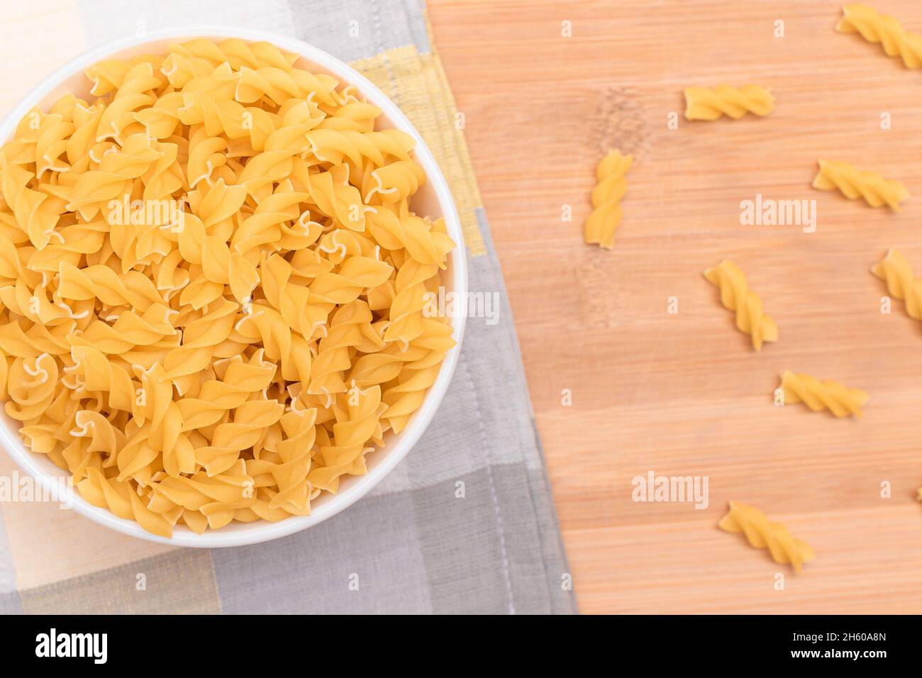 Uncooked Fusilli Pasta in White Bowl on Wooden Board. Raw and Dry ...