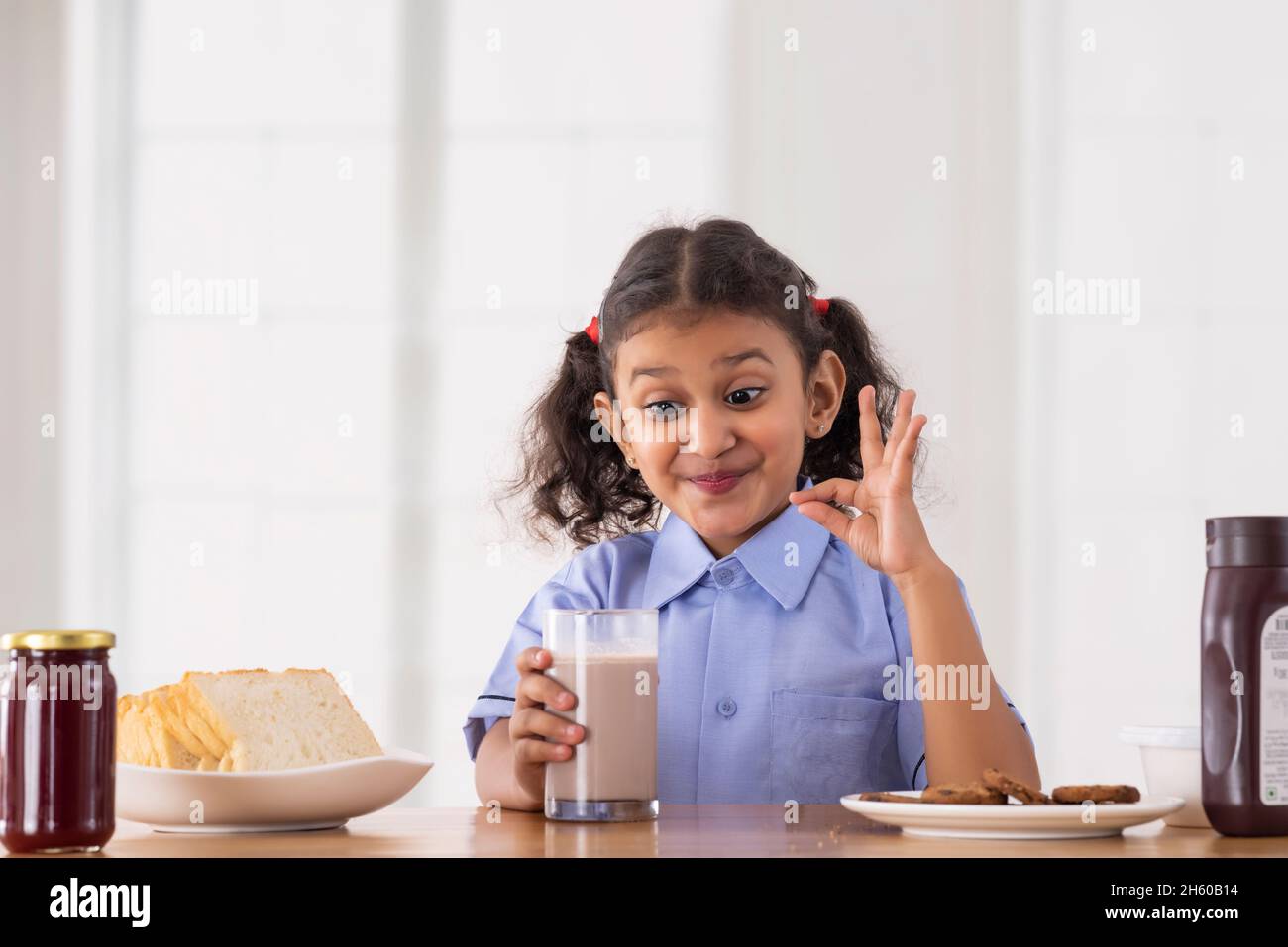 A Girl in school uniform drinking fresh delicious chocolate milkshake ...