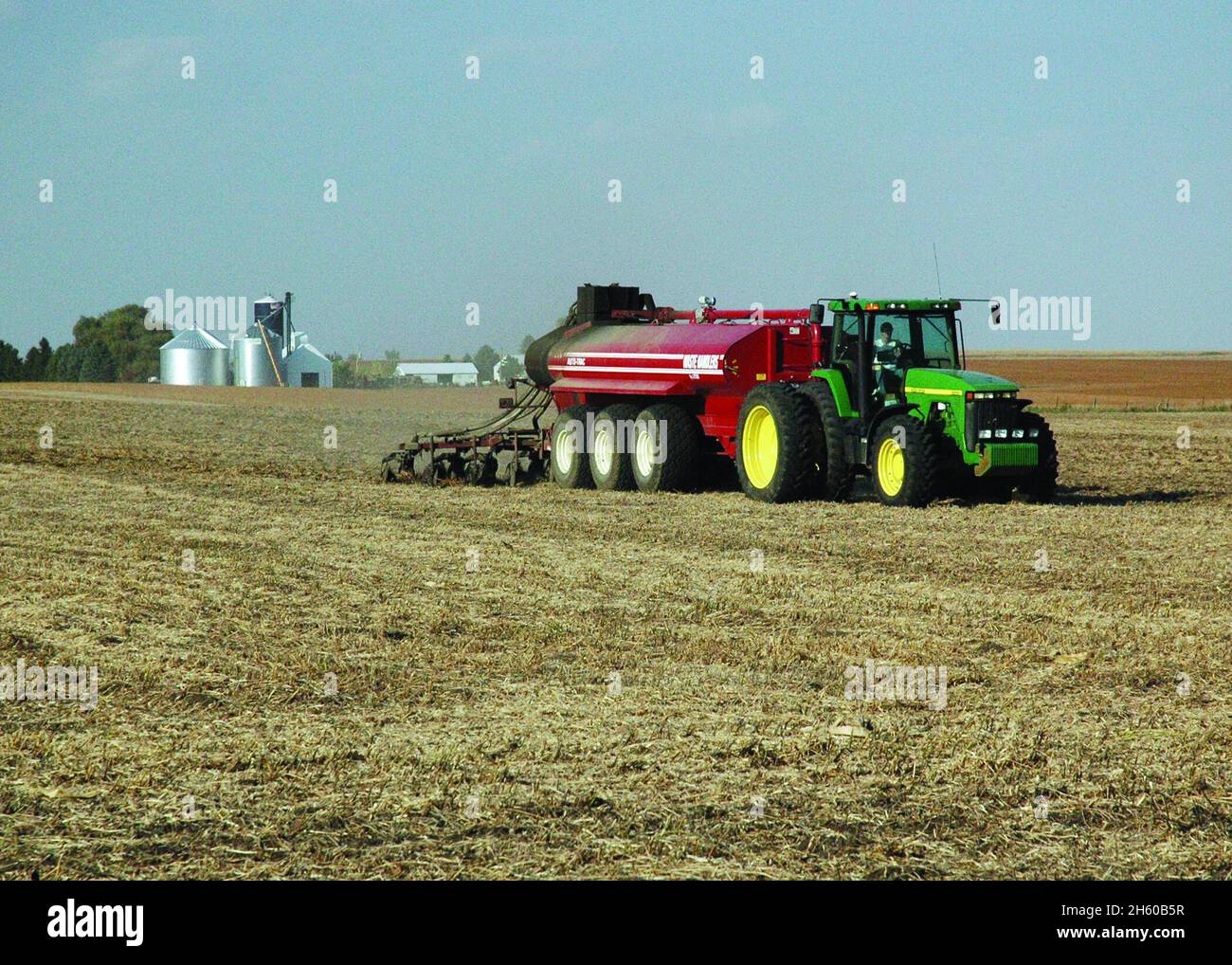 Farmer on his John Deere tractor in a field, tractor facing right ca ...