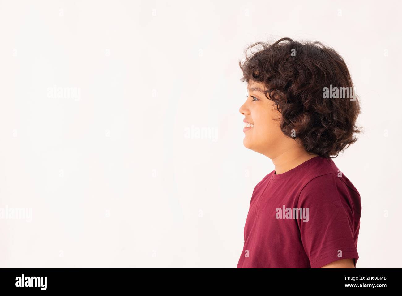Portrait of a boy standing and looking away with smiling Stock Photo ...
