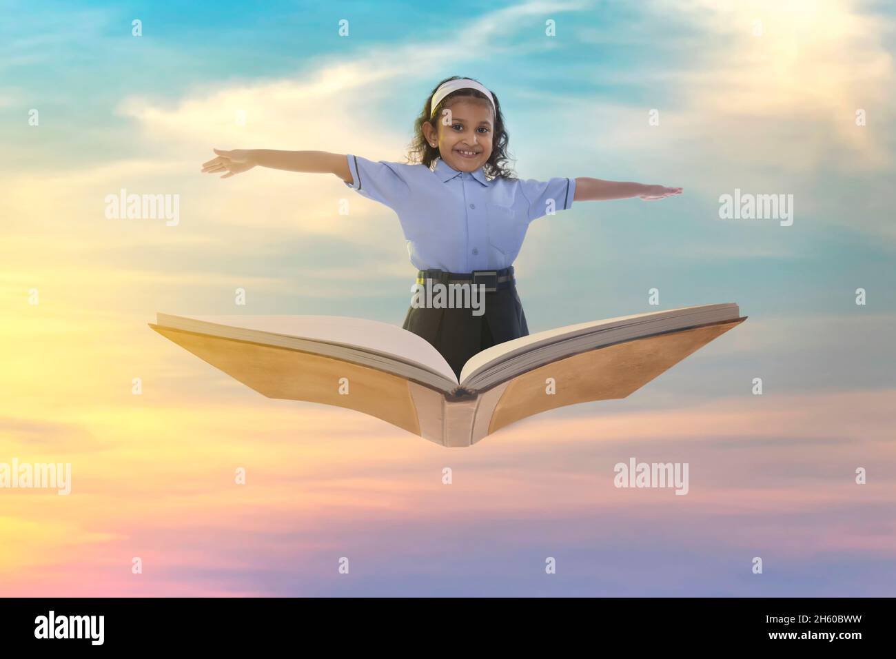 A girl in school uniform flying on book in the sky with open arms Stock ...