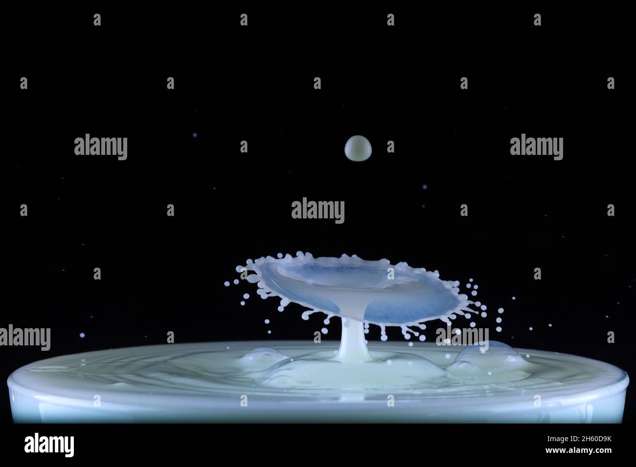 A drop of milk falls into a cup Stock Photo - Alamy