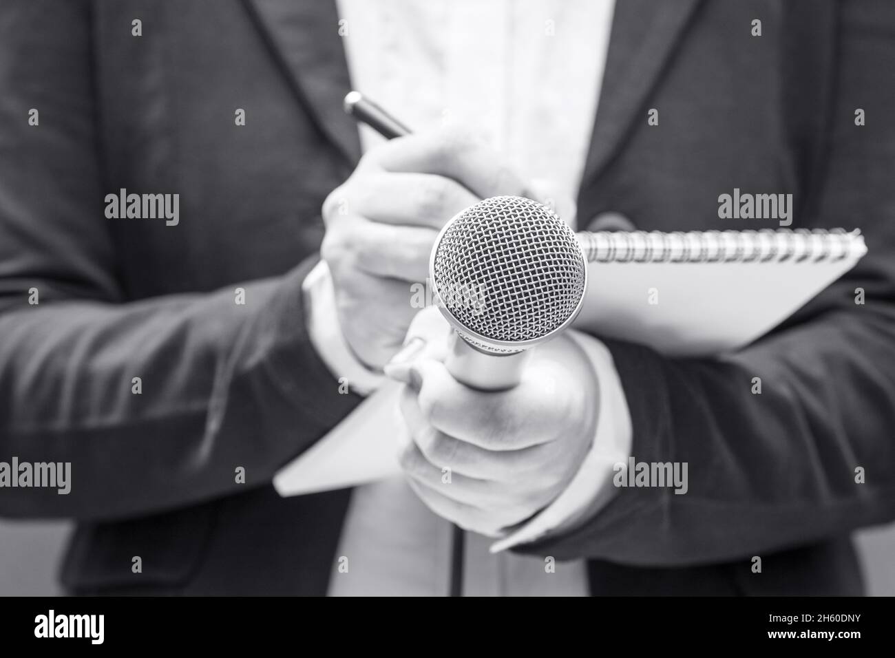 Female journalist at news conference or media event, writing notes ...