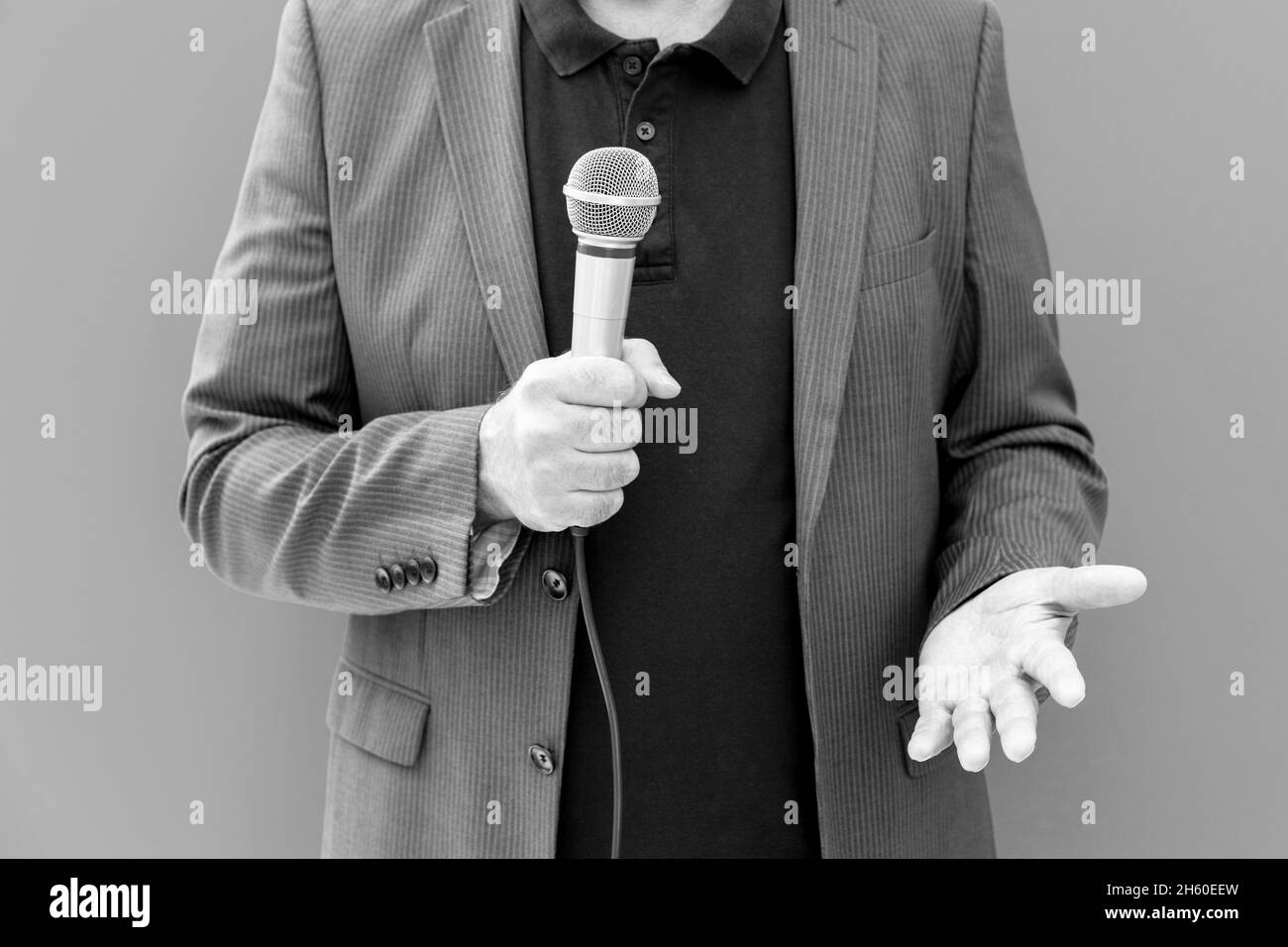 Reporter holding microphone, gesturing during media interview Stock ...