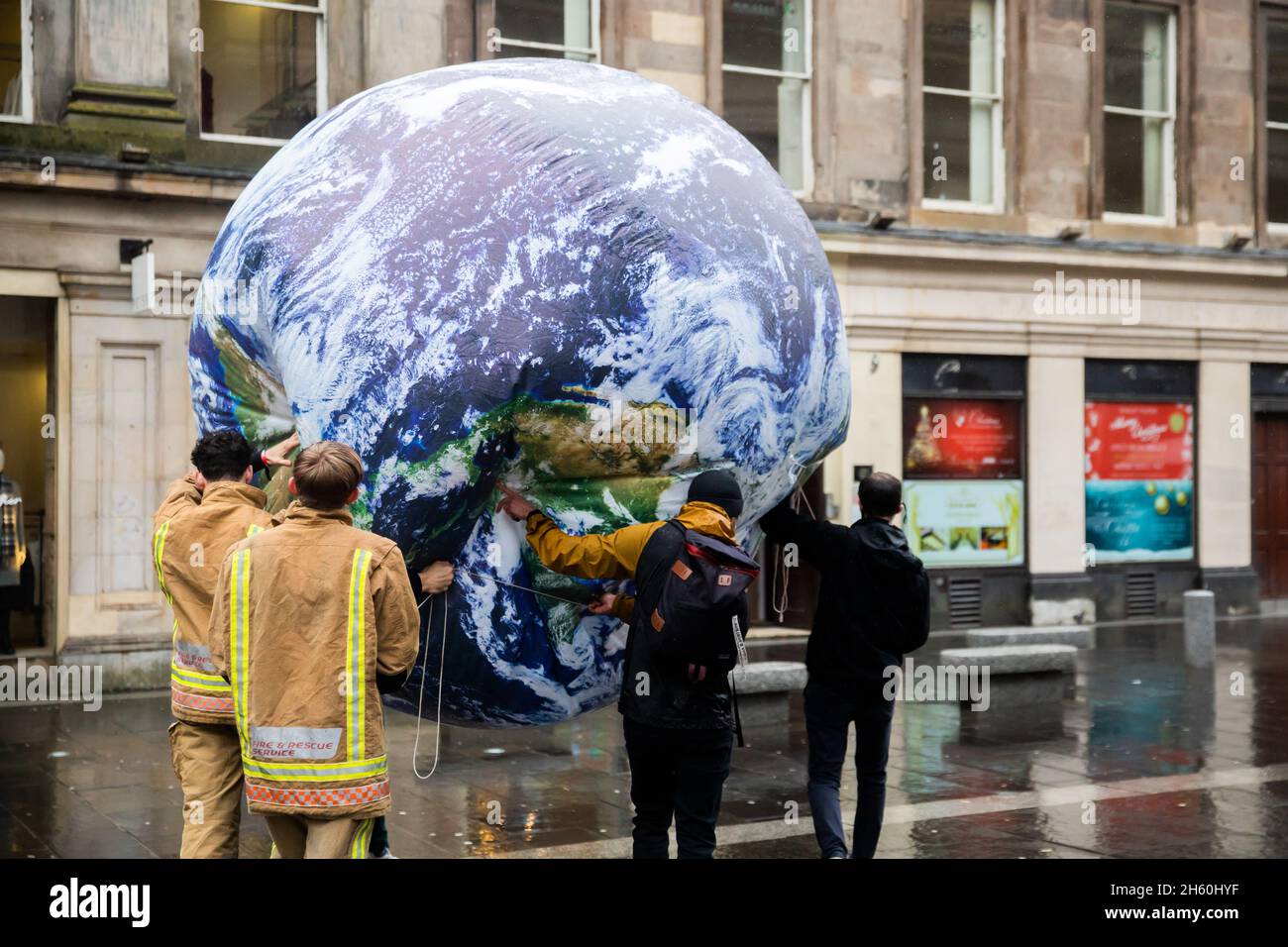 Glasgow, UK. 12th Nov, 2021. Activists carry a globe after a protest by ...