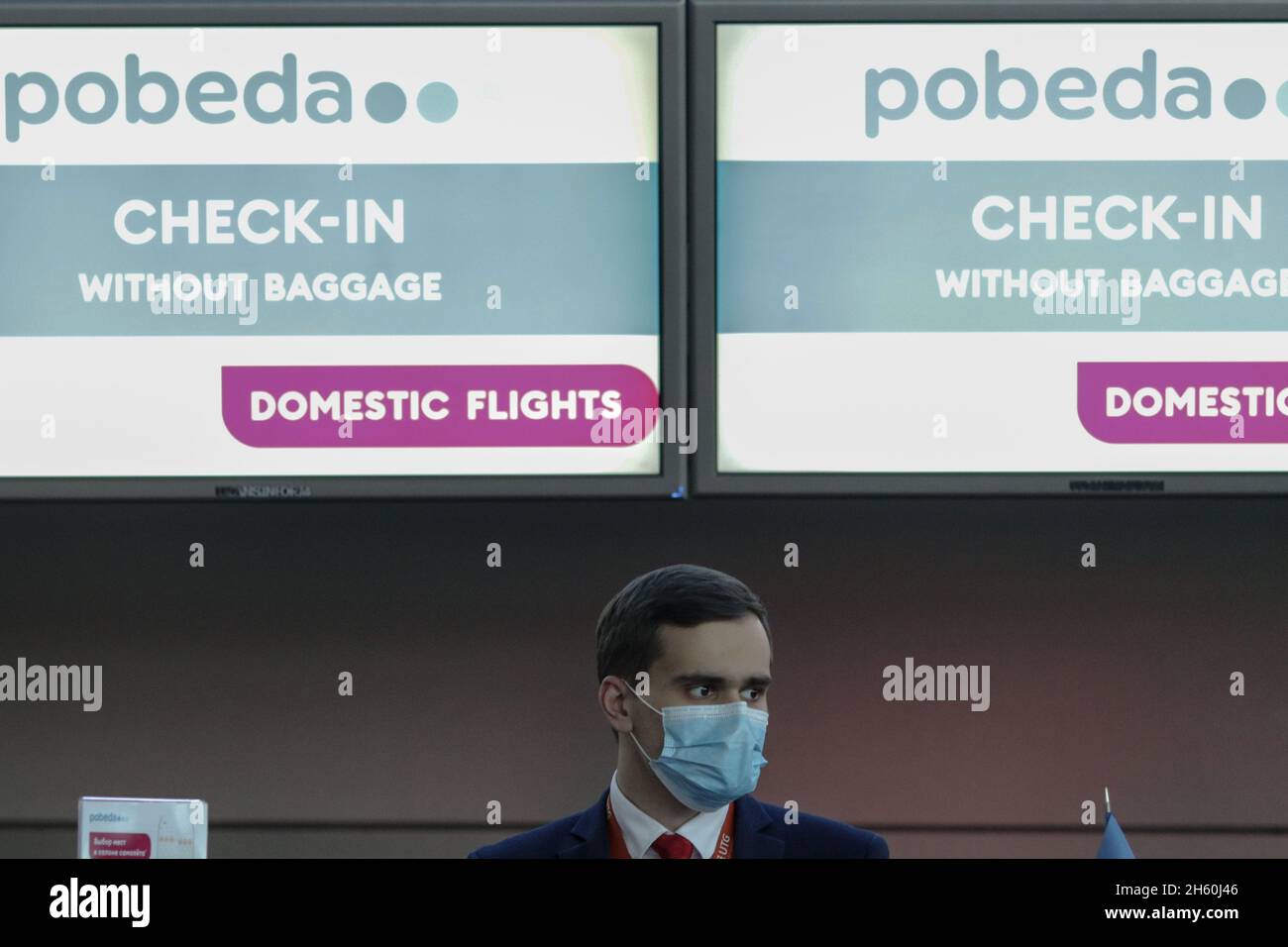 Pobeda Airlines check-in officer stands by his desk at Vnukovo ...