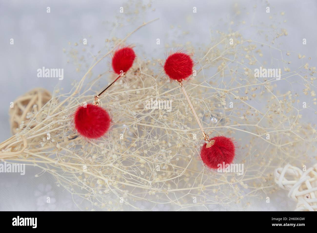 Red pompon earrings in the shape of two fluffy balls.Earrings are next ...