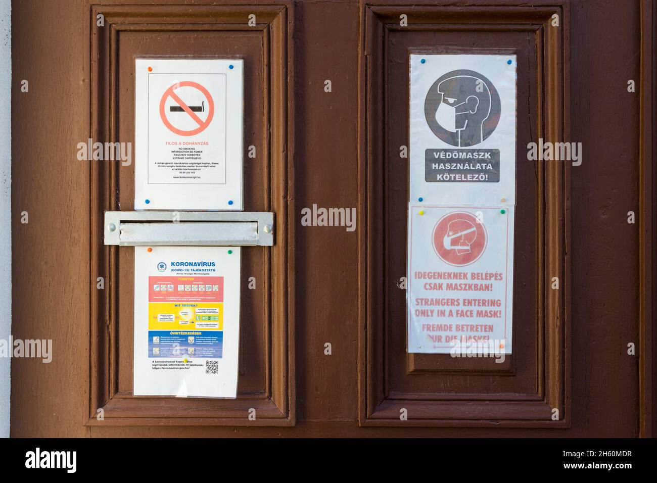 Warning and info signs on school gate about mask wearing and corona ...
