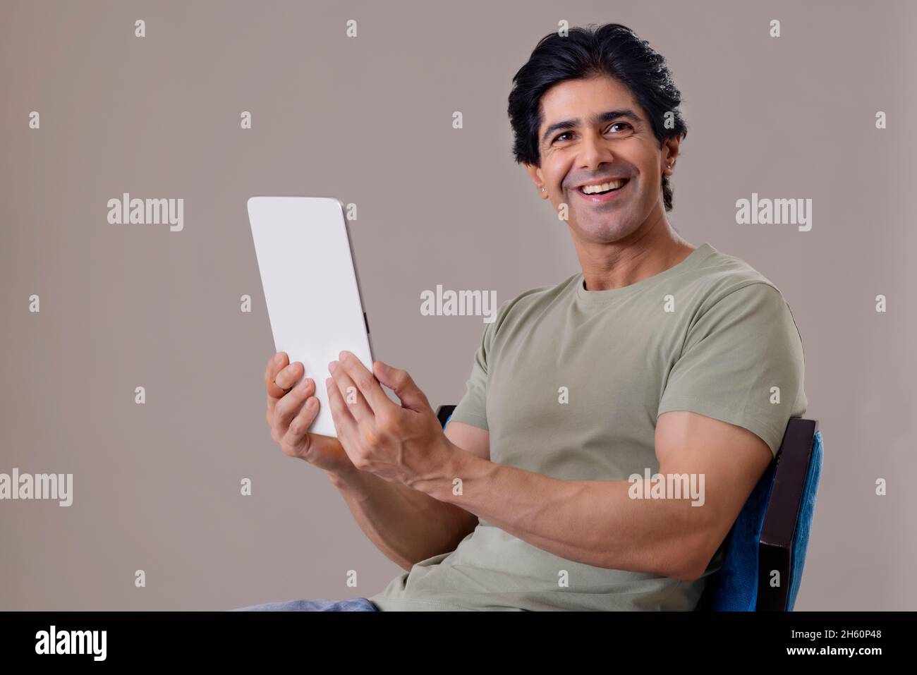 Happy Indian man looking at camera with smiling while holding tablet ...