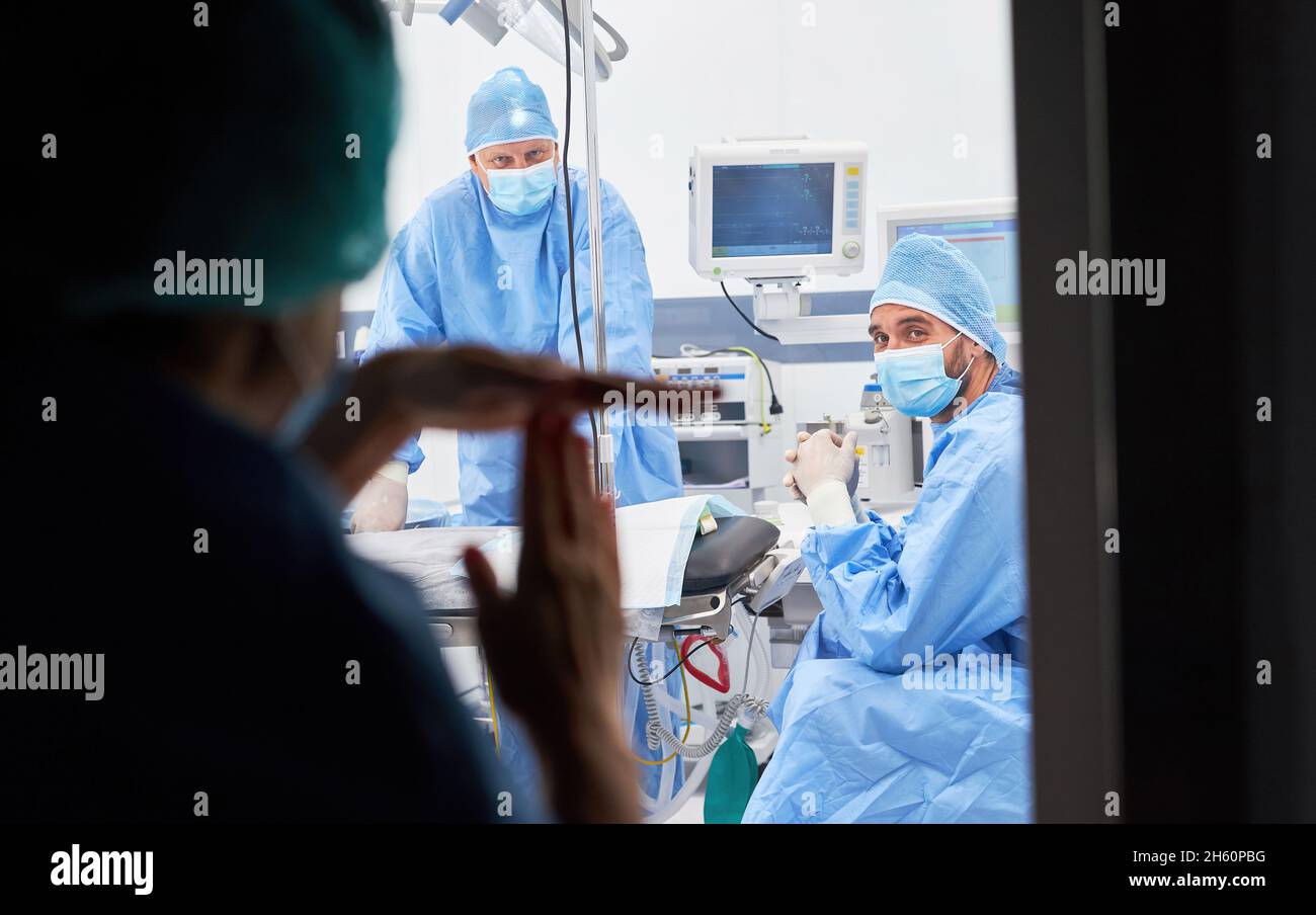 Female doctor gives time-out hand signals to medical team in the ...