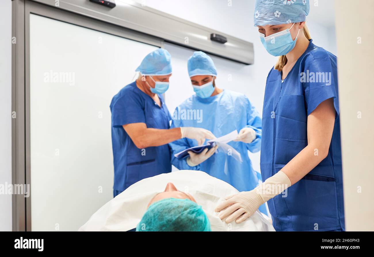 Nurse takes care of patient before the operation with surgery team with ...