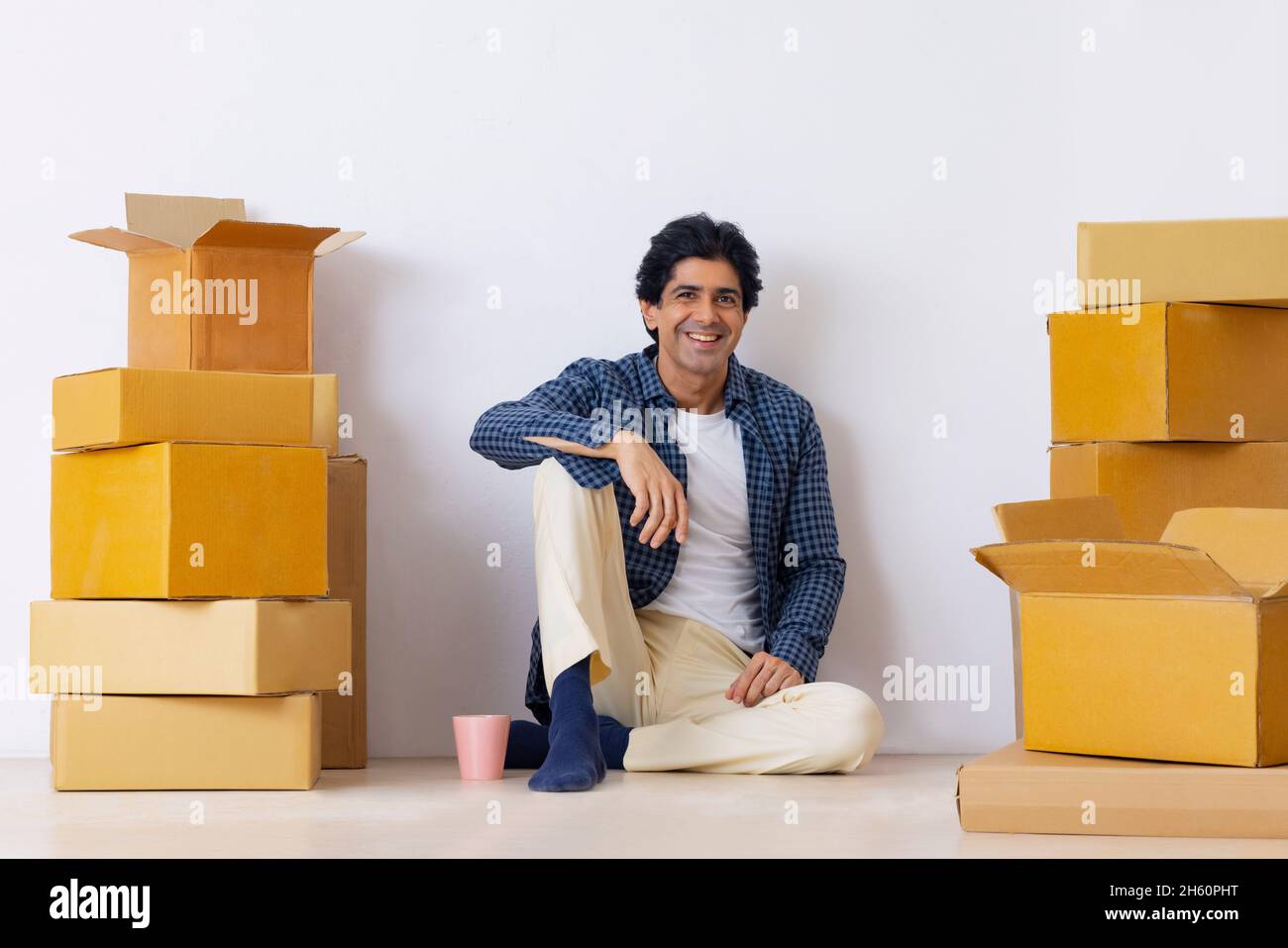 Indian man taking rest during shifting to new home Stock Photo - Alamy